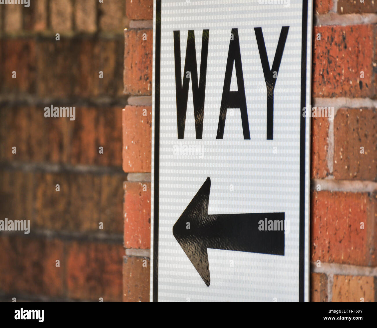 Sign with Arrow on Brick Wall Stock Photo - Alamy