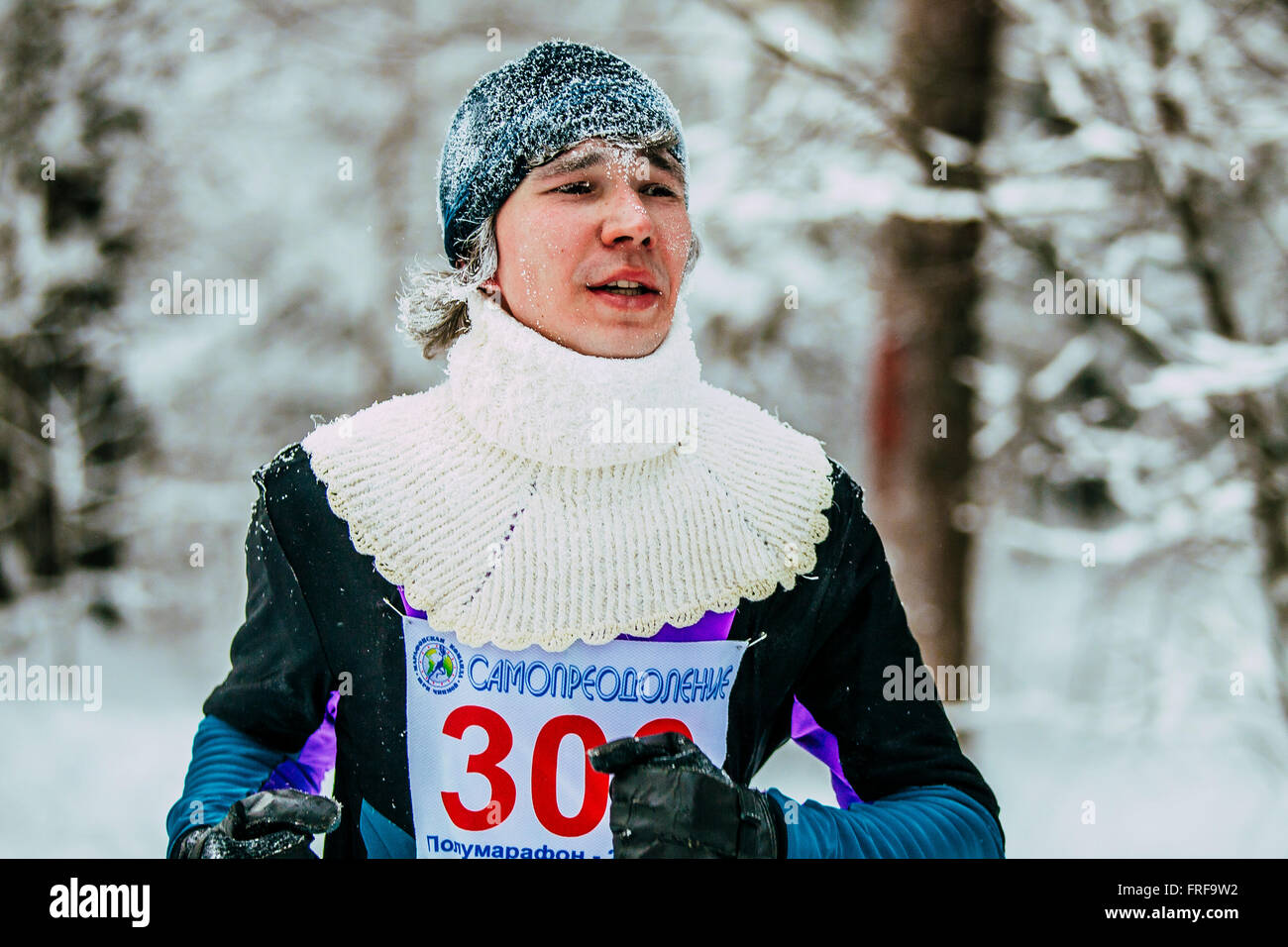 closeup face in frost young athlete runner in winter forest during ...