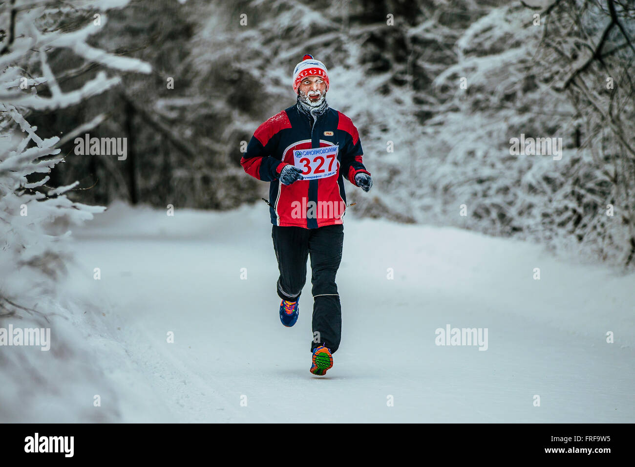 male athlete runner in winter forest. face in frost and ice during ...