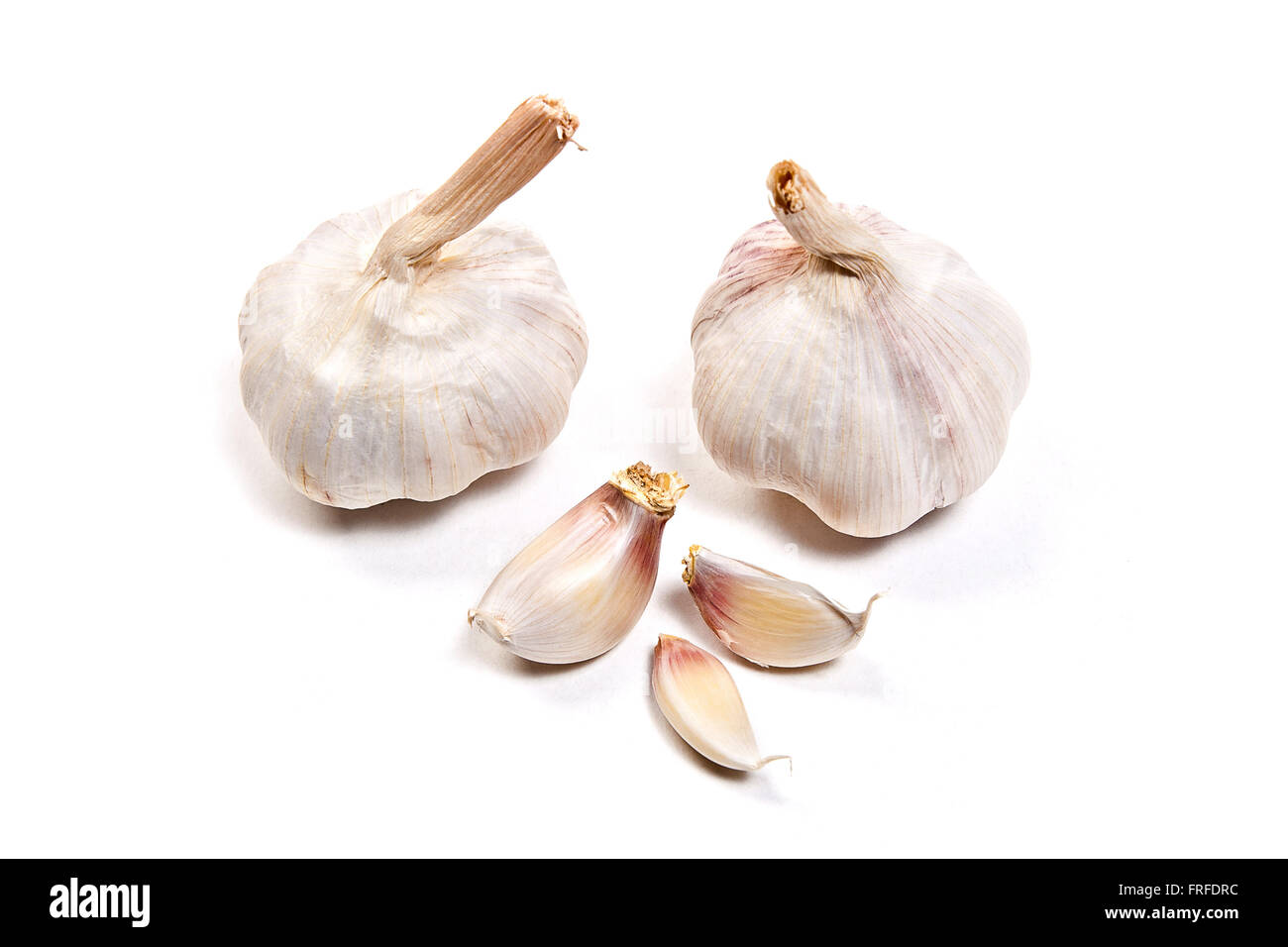 Close up view of garlic bulb and three cloves of garlic arranged on a ...