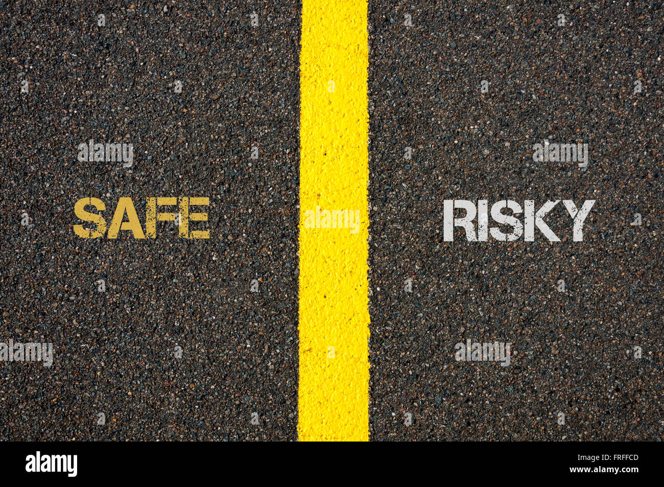 Antonym concept of SAFE versus RISKY written over tarmac, road marking ...