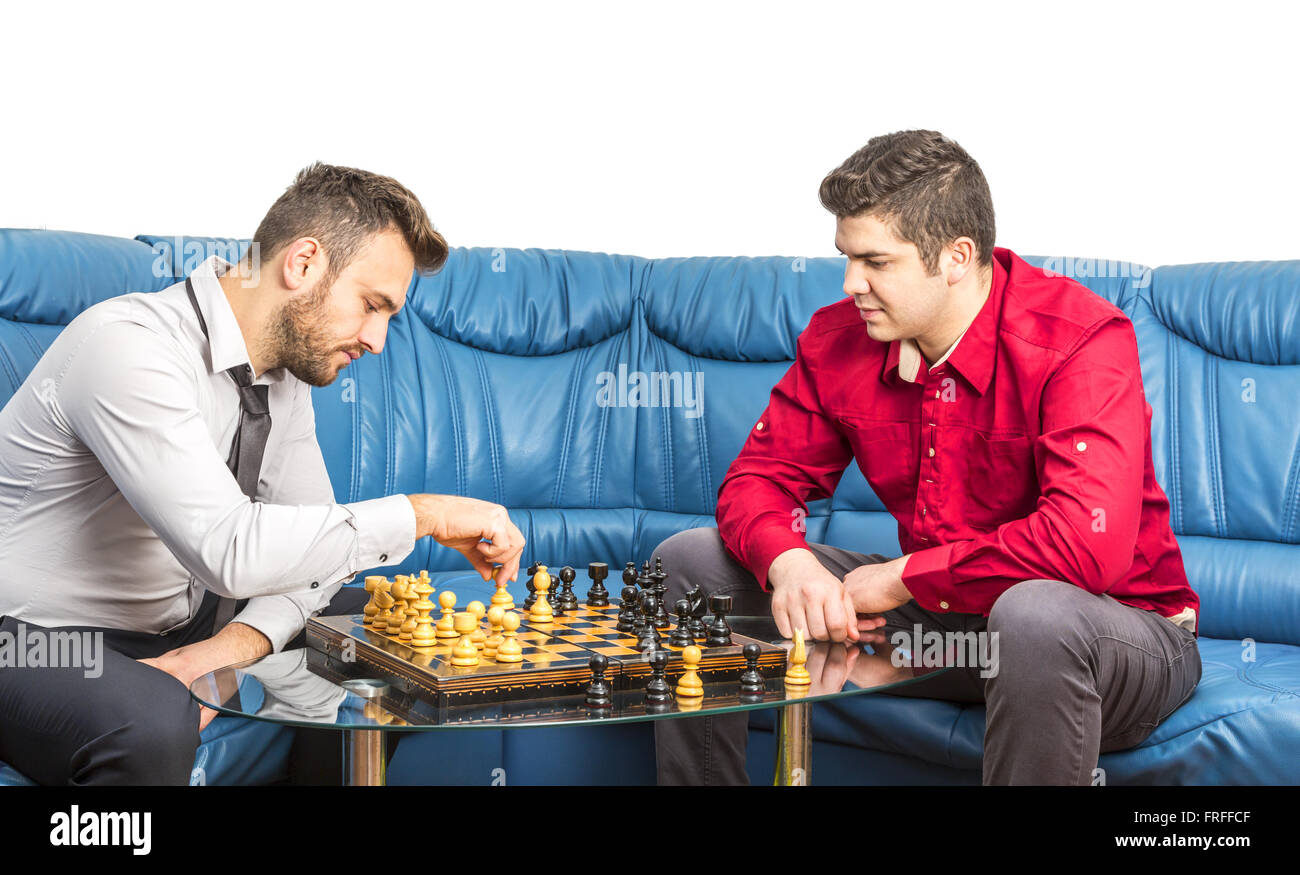 Two friends playing chess on a blue couch Stock Photo - Alamy