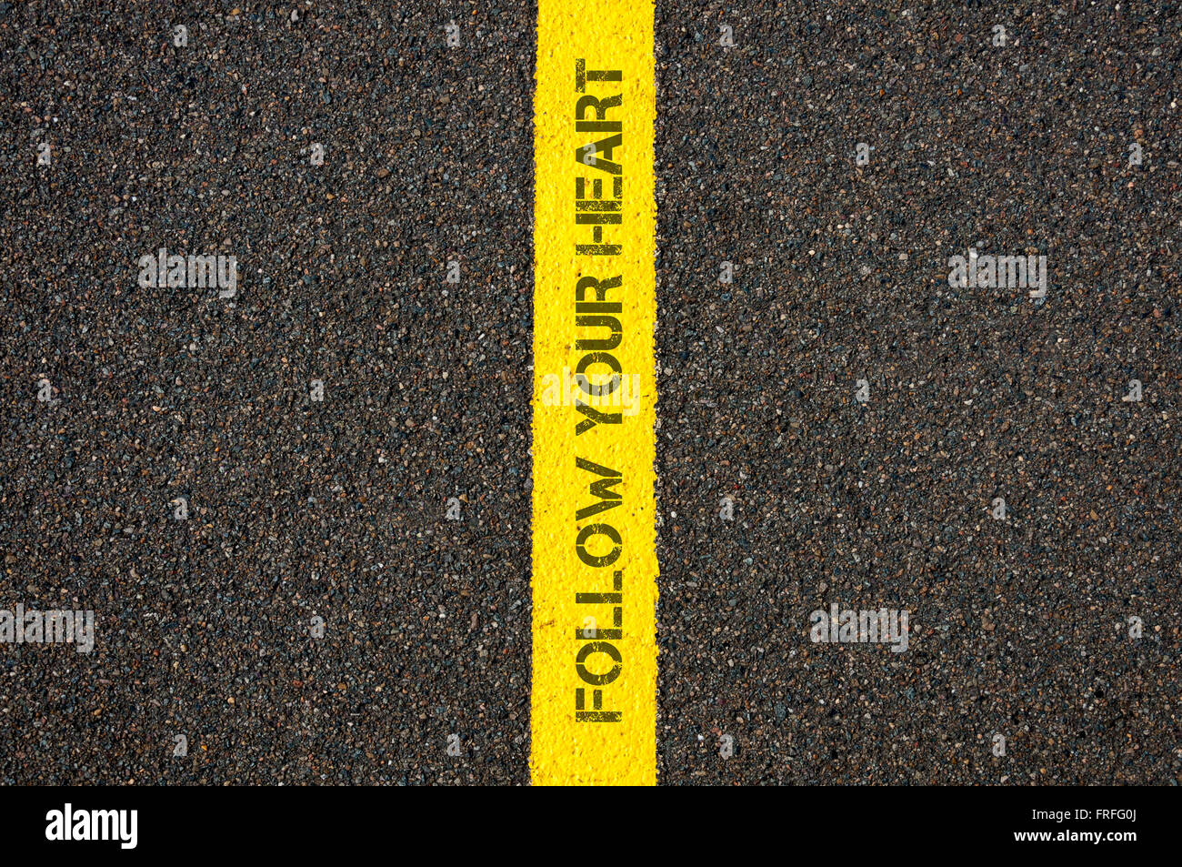 Road marking yellow paint dividing line with words FOLLOW YOUR HEART ...