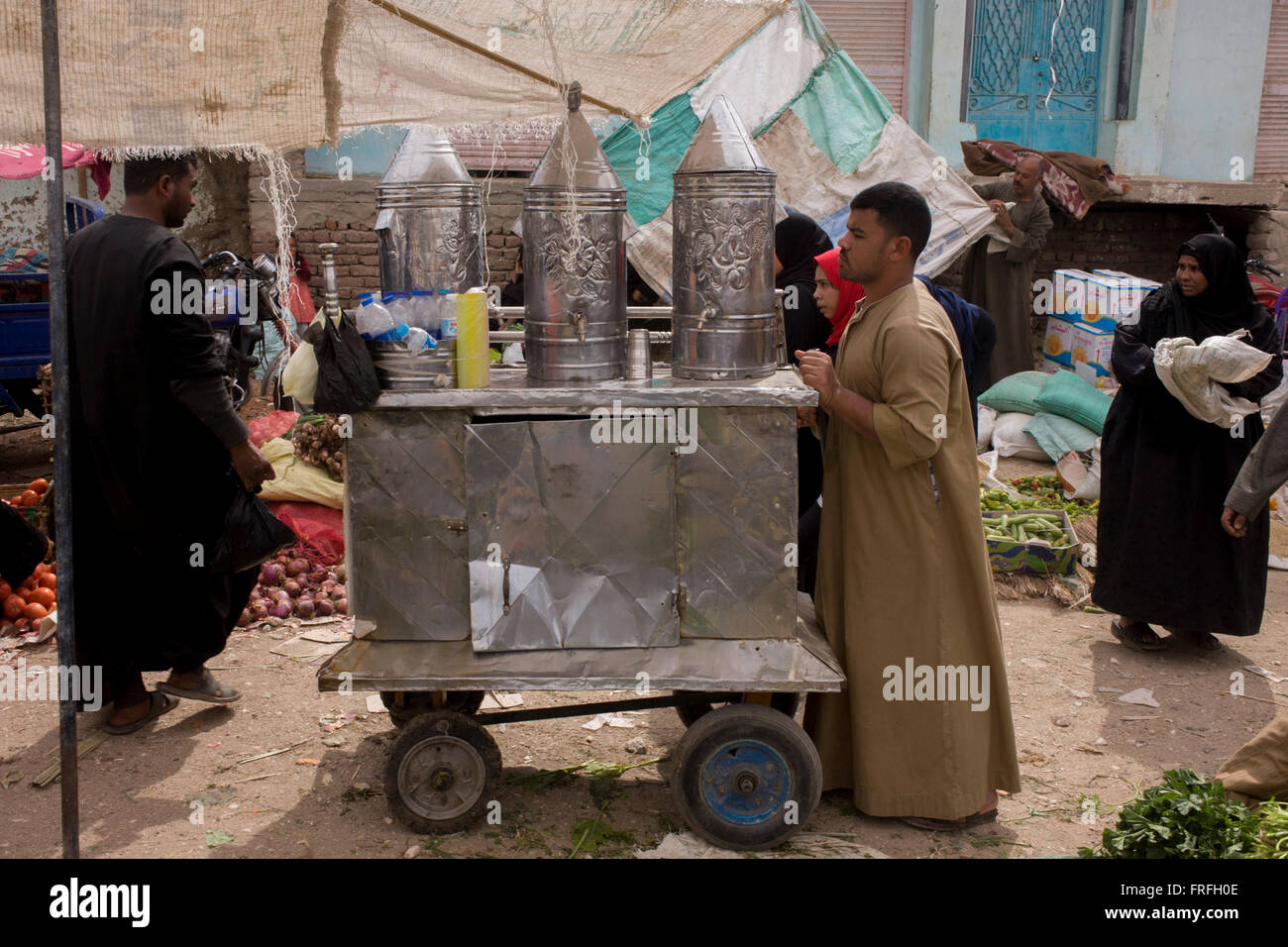 A chai (tea) seller walks through the weekly market at Qurna, a village ...