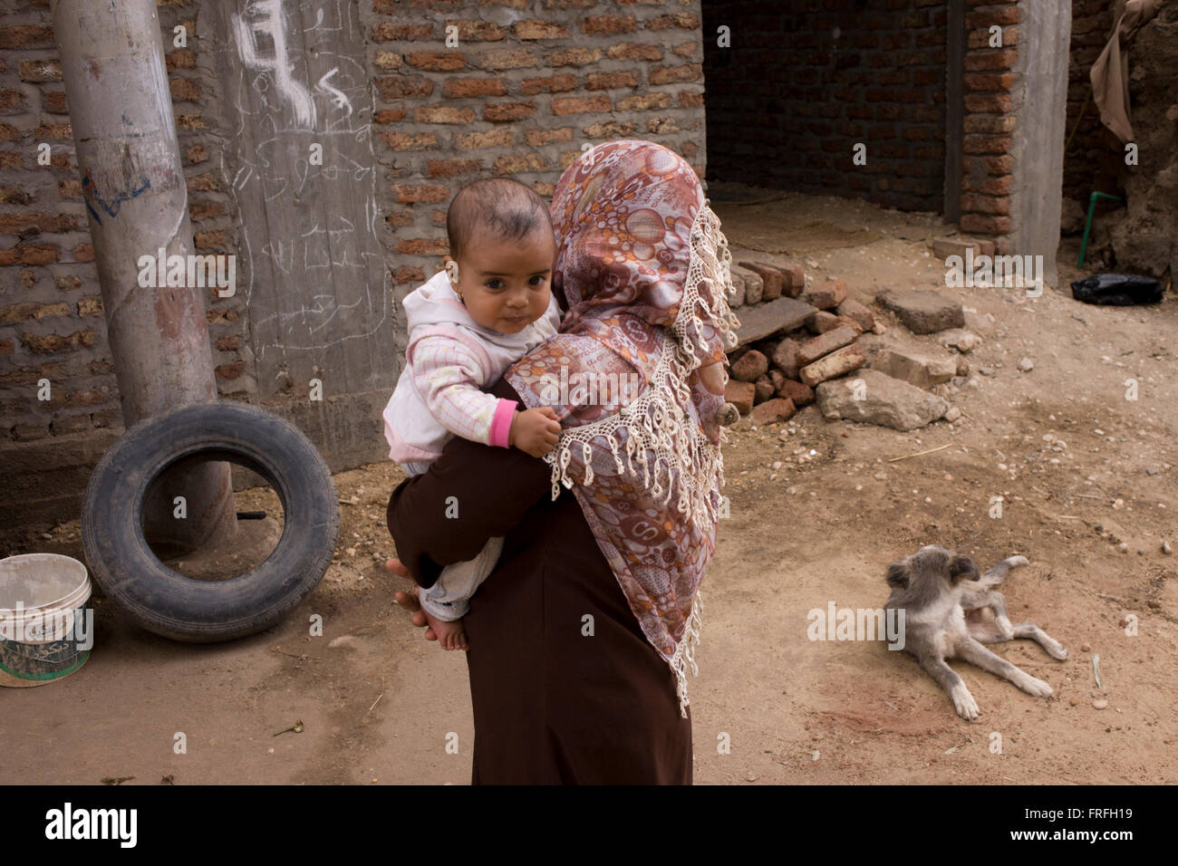 A local mother holds her youngest child in Bairat, a village on the ...