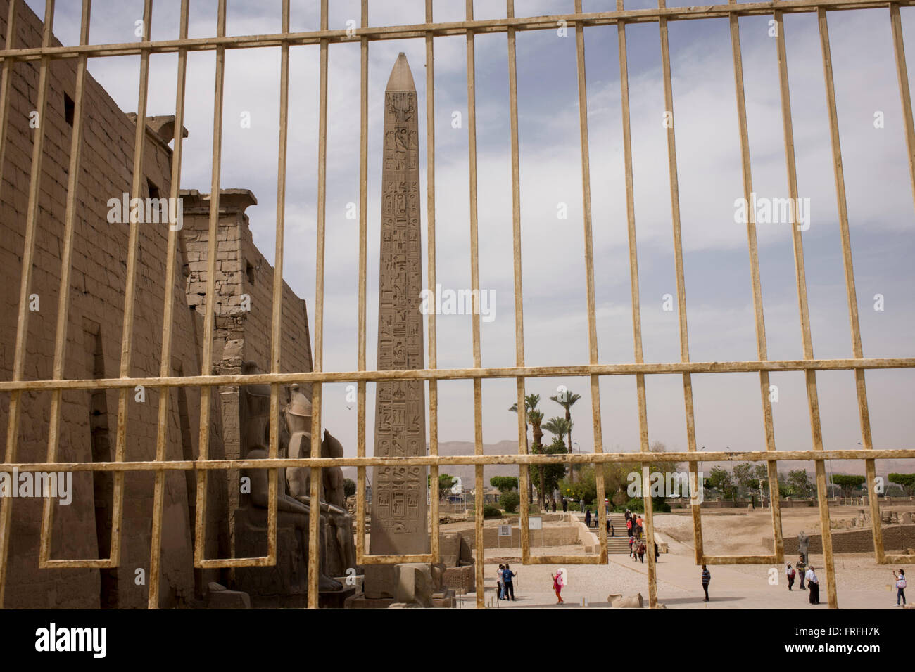 Seen through rusting railings, tourists and the tall Obelisk at the ...