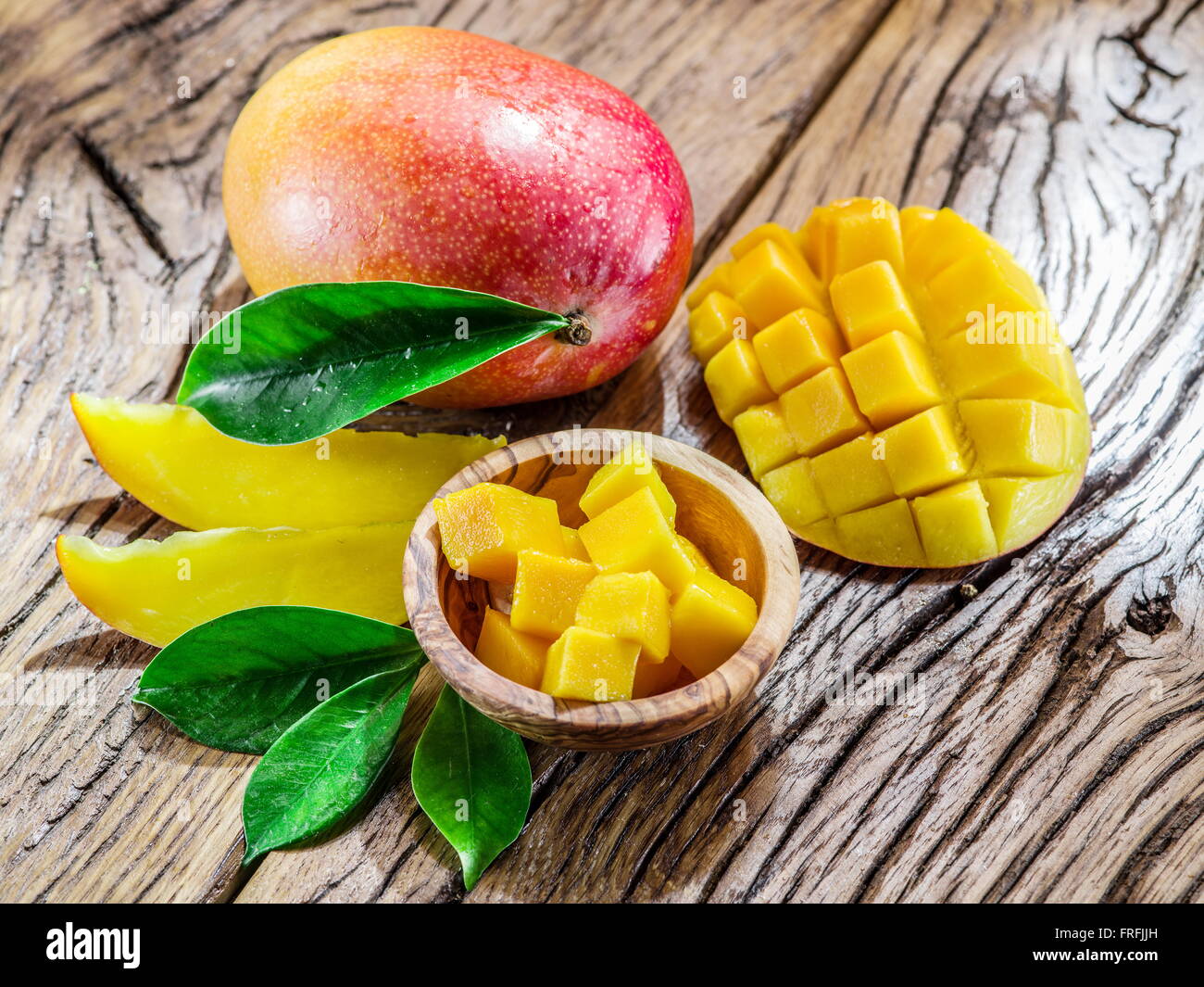 Mango fruit and mango cubes on the wooden table Stock Photo - Alamy