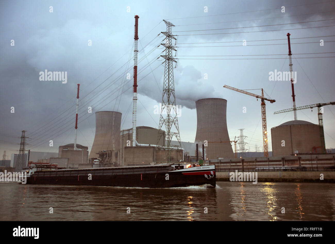 A river barge passes by Tihange nuclear power plant, with steam risimg ...