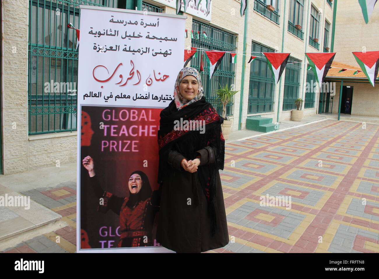 Palestinian teacher Hanan al-Hrub pictured next to a poster featuring ...