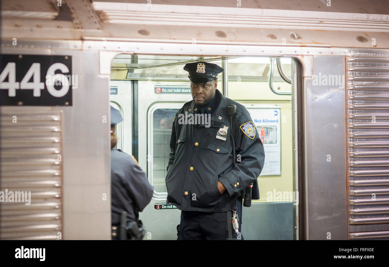 New York, USA. 22nd Mar, 2016. An NYPD officer riding a subway train ...
