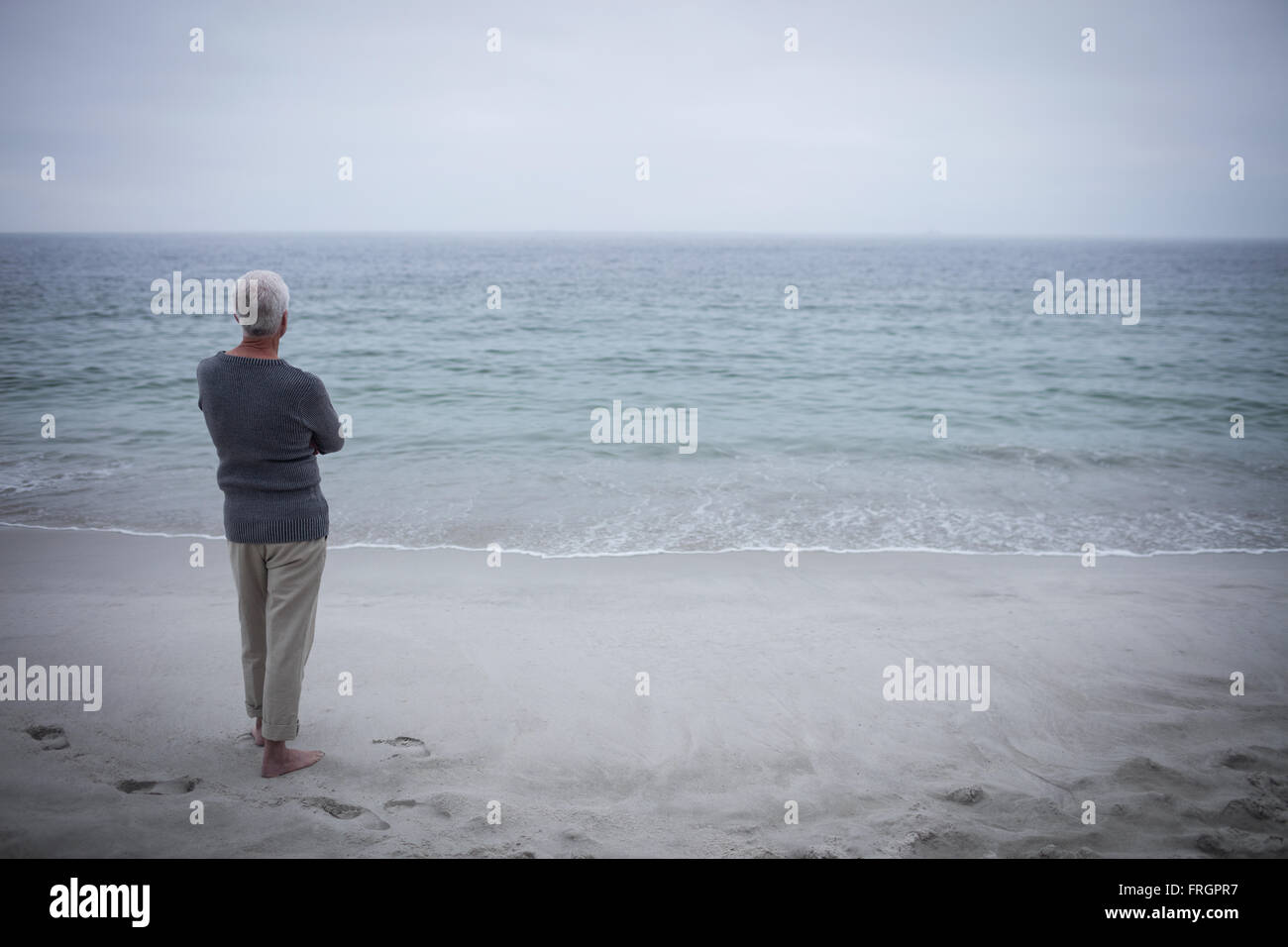 Rear view of senior man looking at sea Stock Photo - Alamy