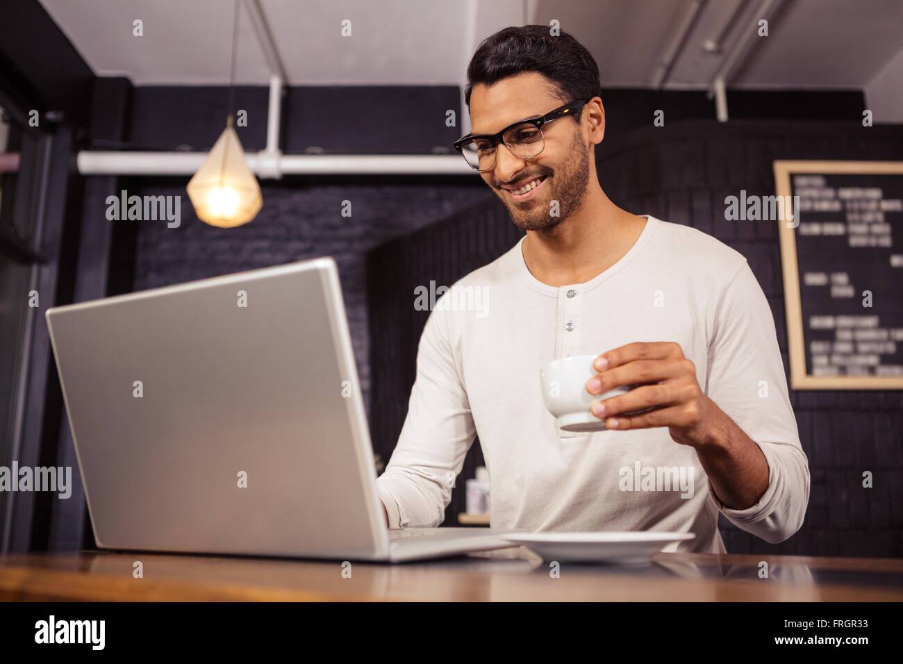 Man using a laptop and drinking coffee Stock Photo - Alamy