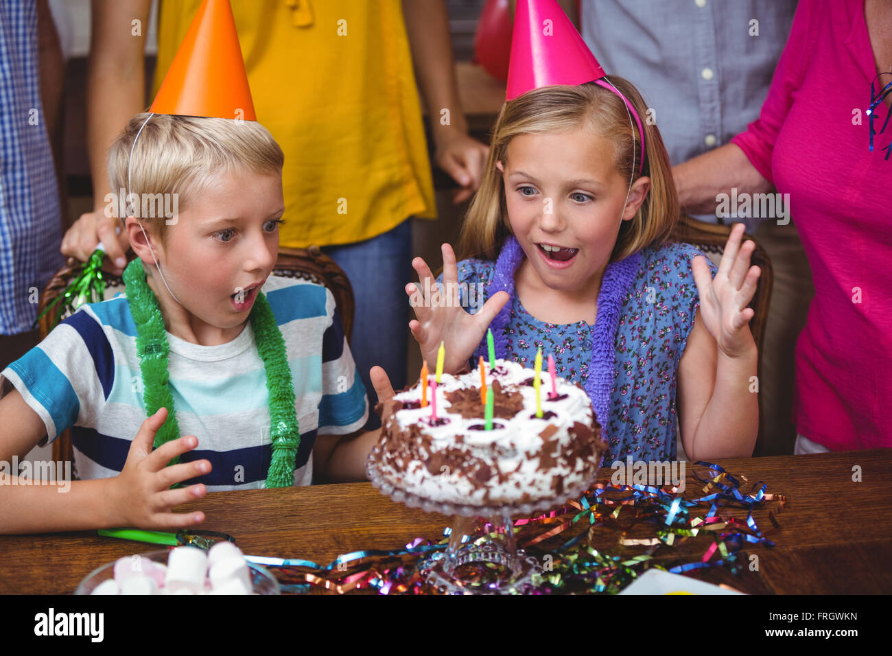 Shocked siblings with birthday cake Stock Photo - Alamy