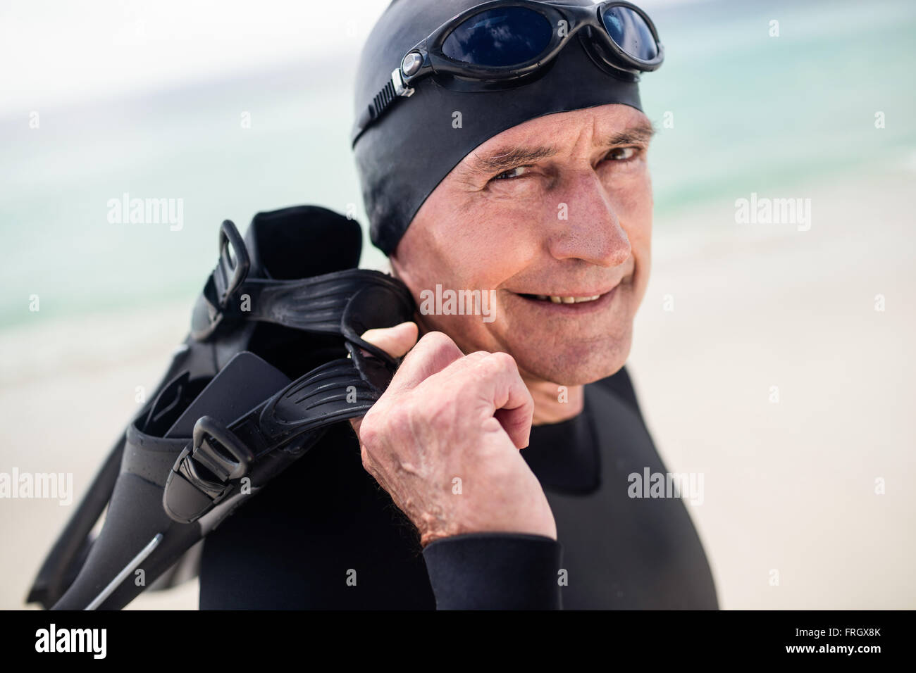 Senior man with flipper standing on beach Stock Photo - Alamy