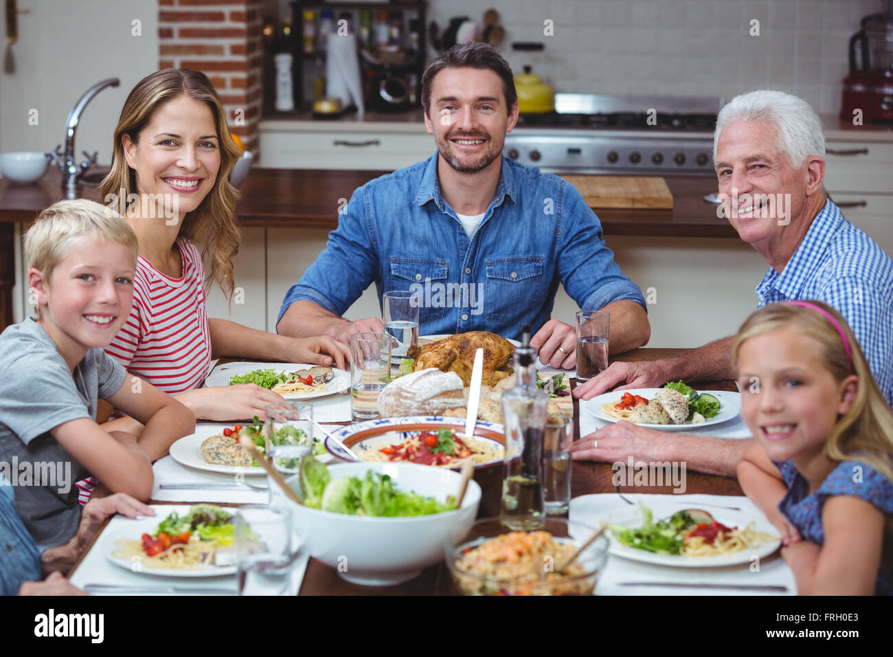 Smiling multi generation family sitting at dining table Stock Photo - Alamy