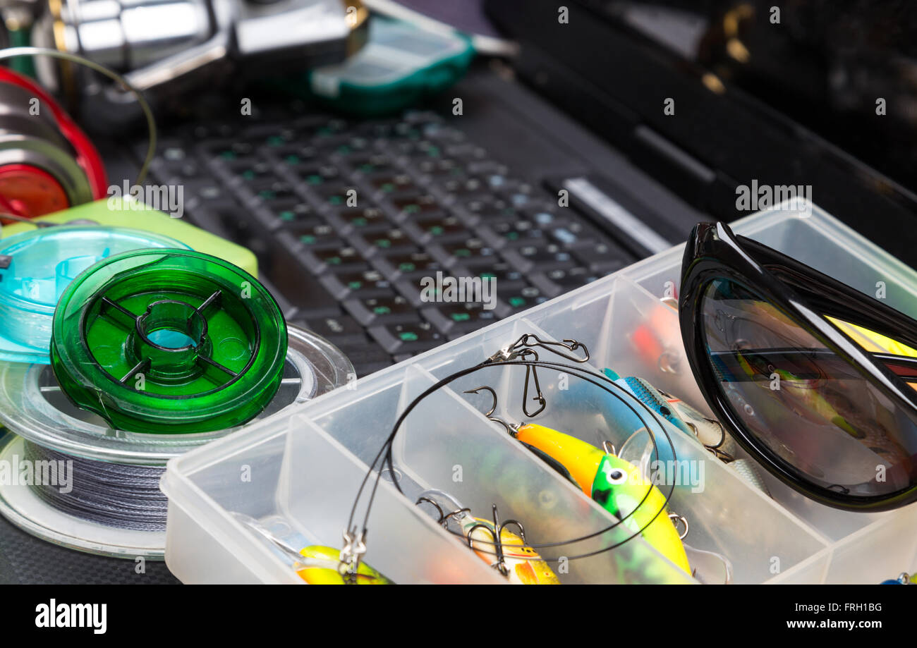 different fishing tackles on dark keyboard a black notebook. Concept ...