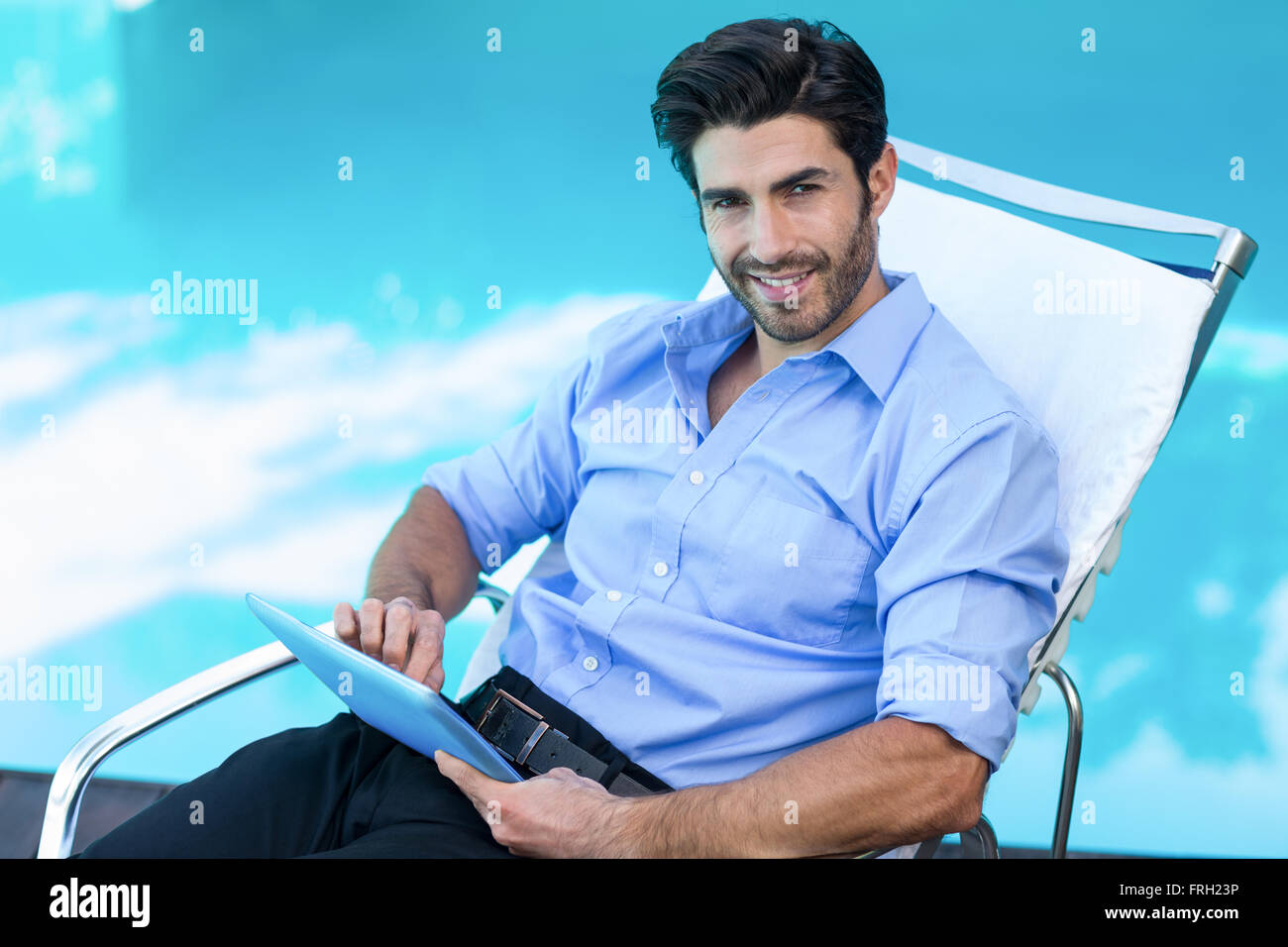 Smart man using digital tablet near pool Stock Photo - Alamy