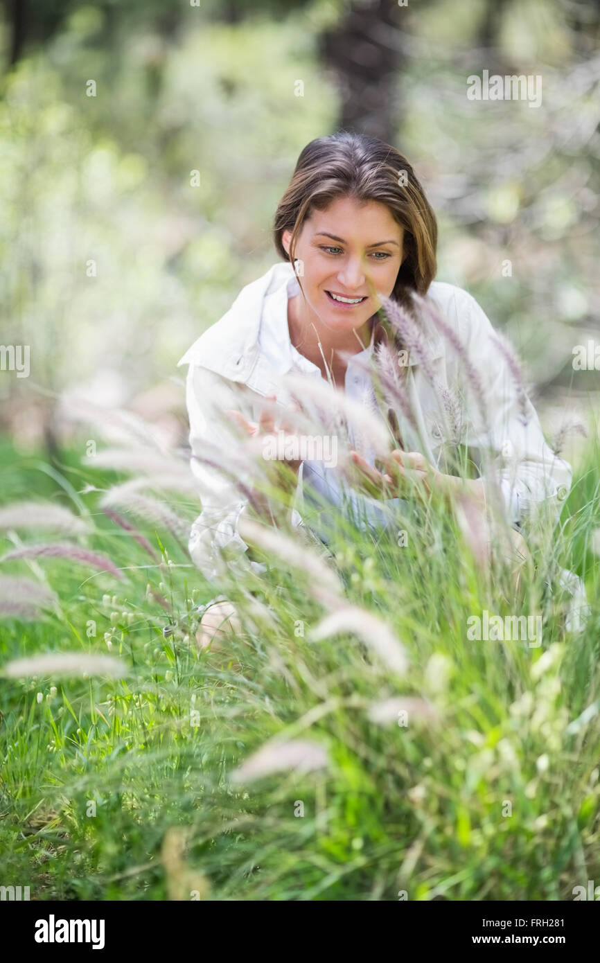 Young woman looking down on grassy field Stock Photo - Alamy