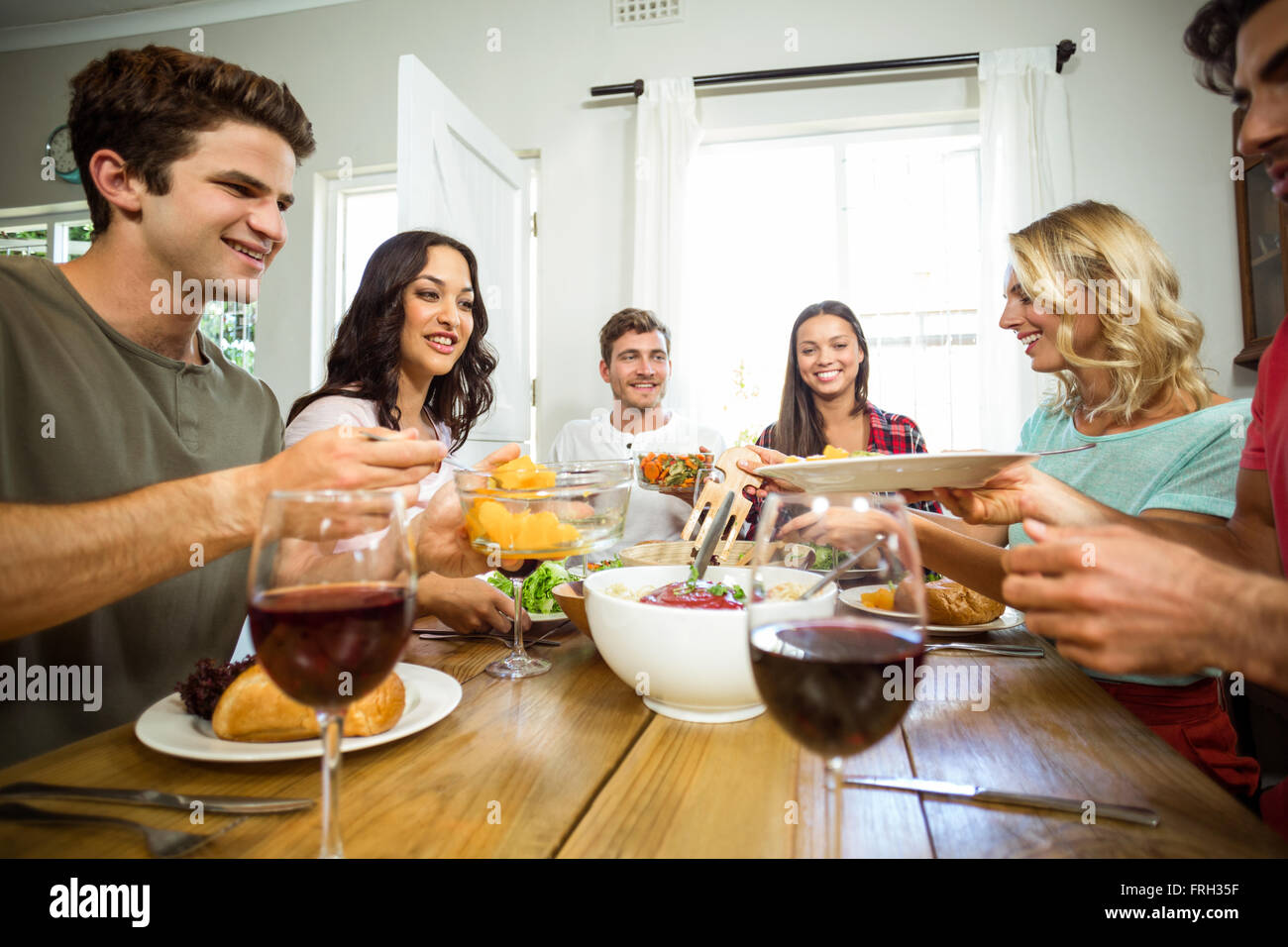 Happy friends having lunch at table Stock Photo - Alamy