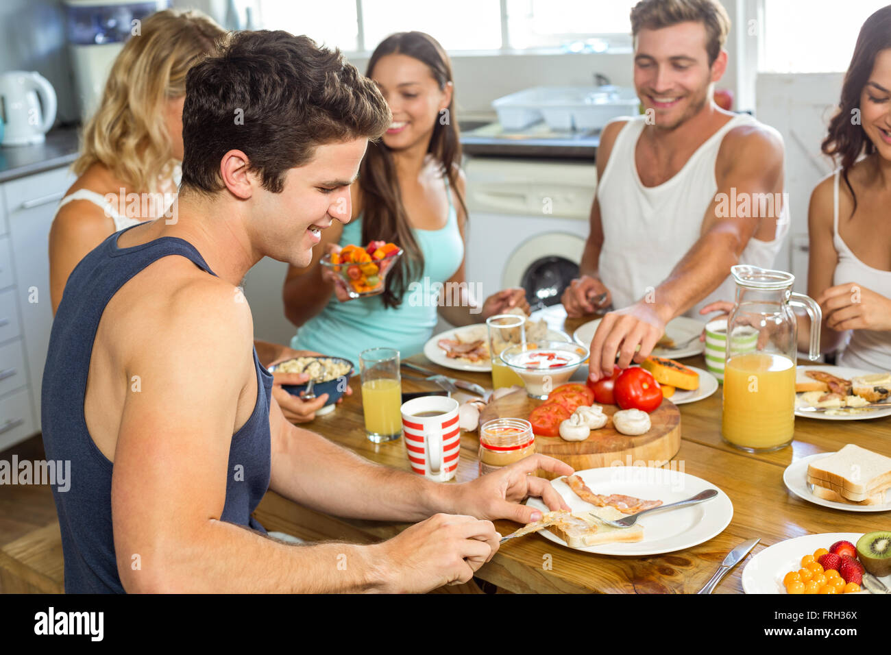 Young man having breakfast with friends at home Stock Photo - Alamy