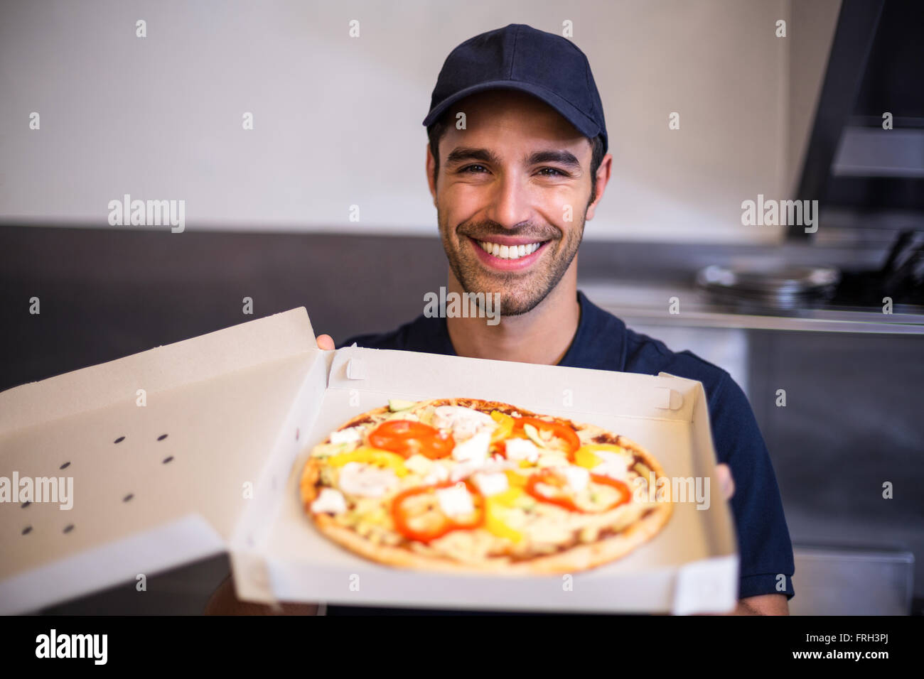 Pizza delivery man showing box Stock Photo - Alamy