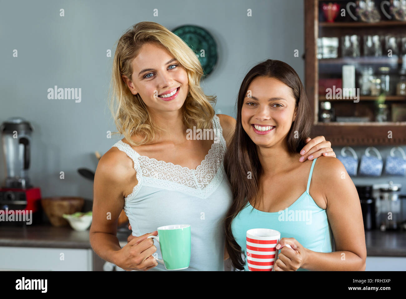 Portrait of happy female friends having coffee in kitchen Stock Photo ...
