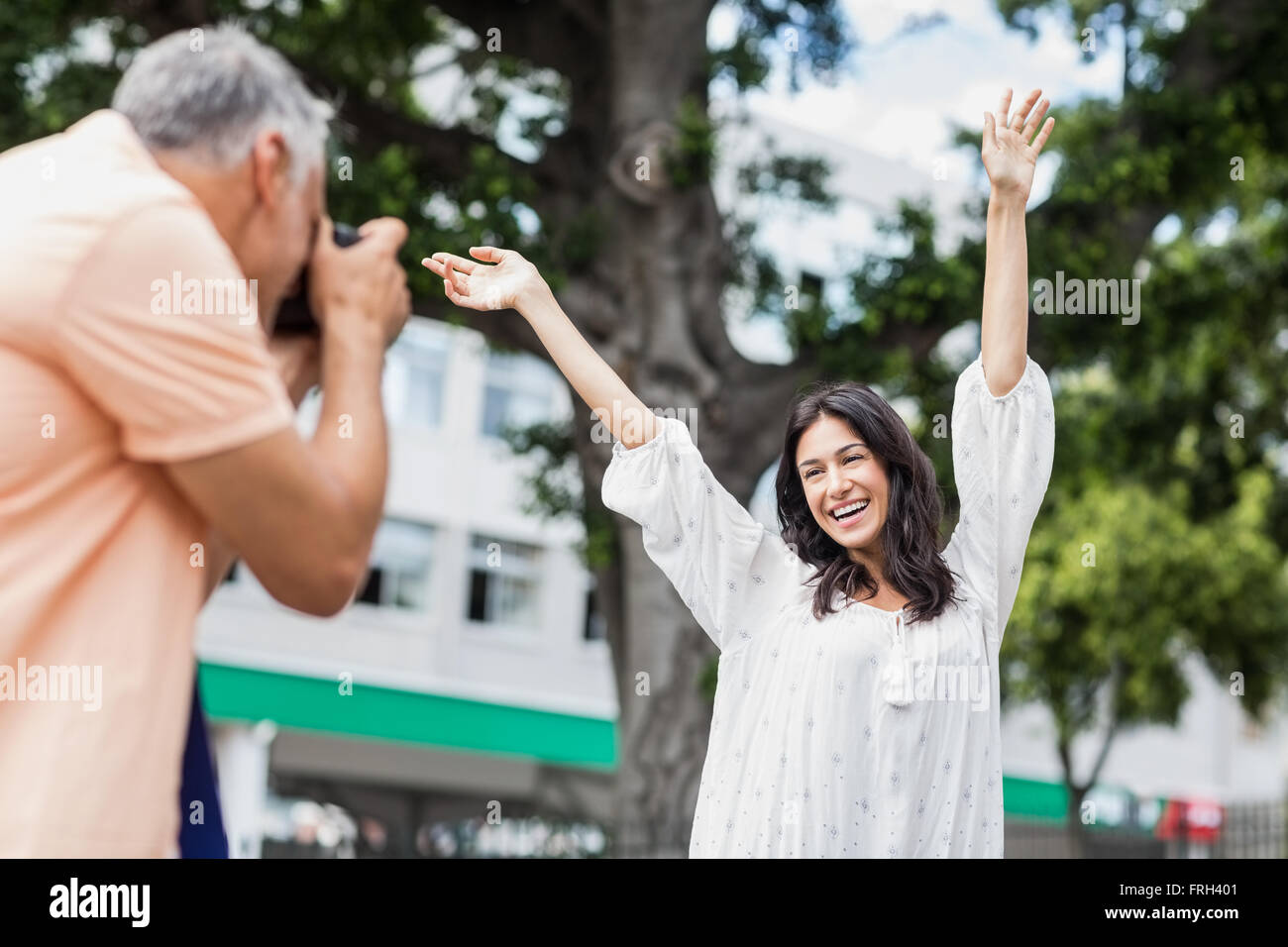 Man photographing woman with arms raised Stock Photo - Alamy