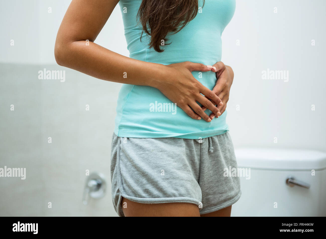 Woman touching her belly Stock Photo - Alamy