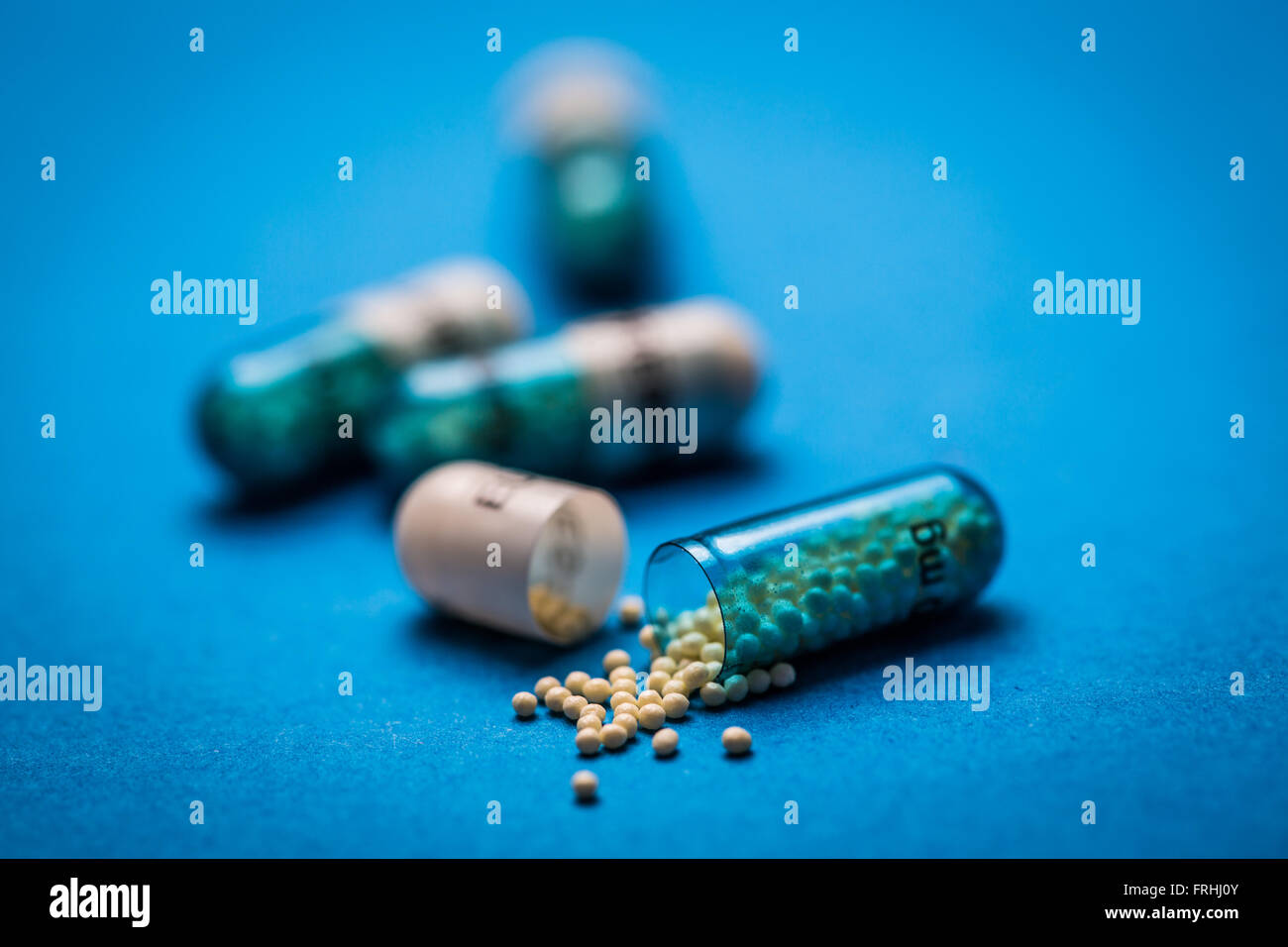 Capsule split in two, containing microgranules Stock Photo - Alamy