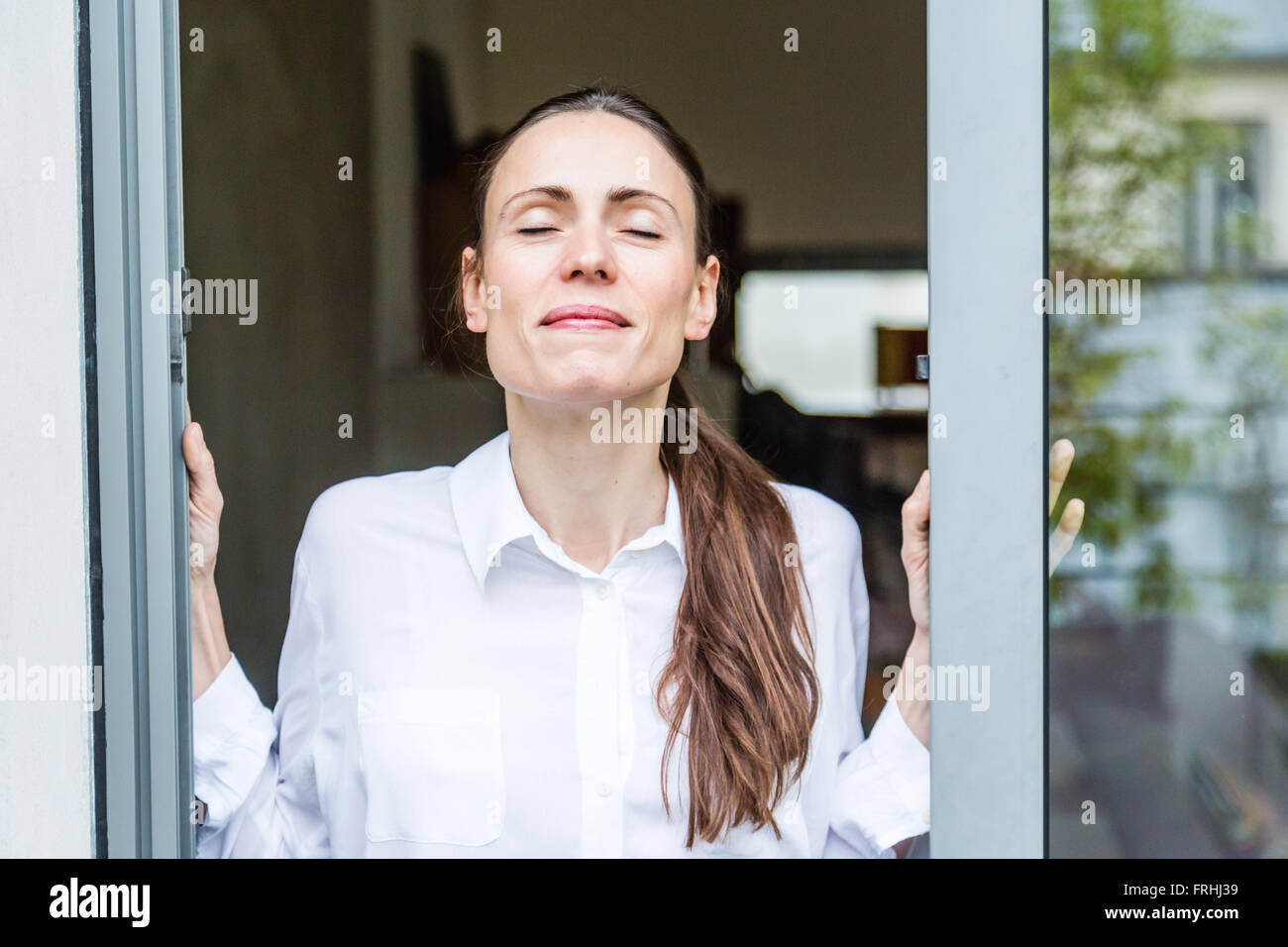 Woman opening window Stock Photo - Alamy