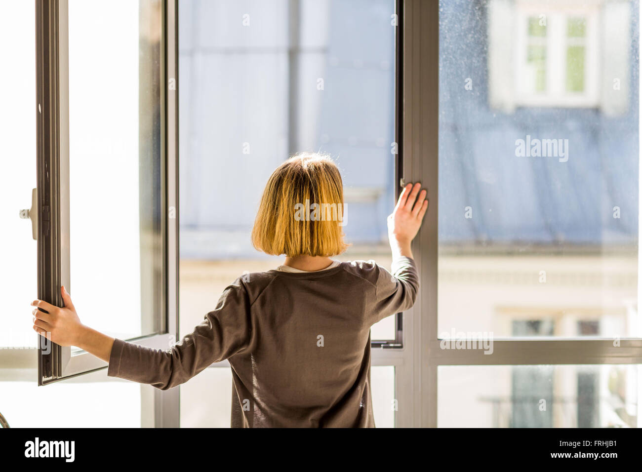 Woman opening window Stock Photo - Alamy