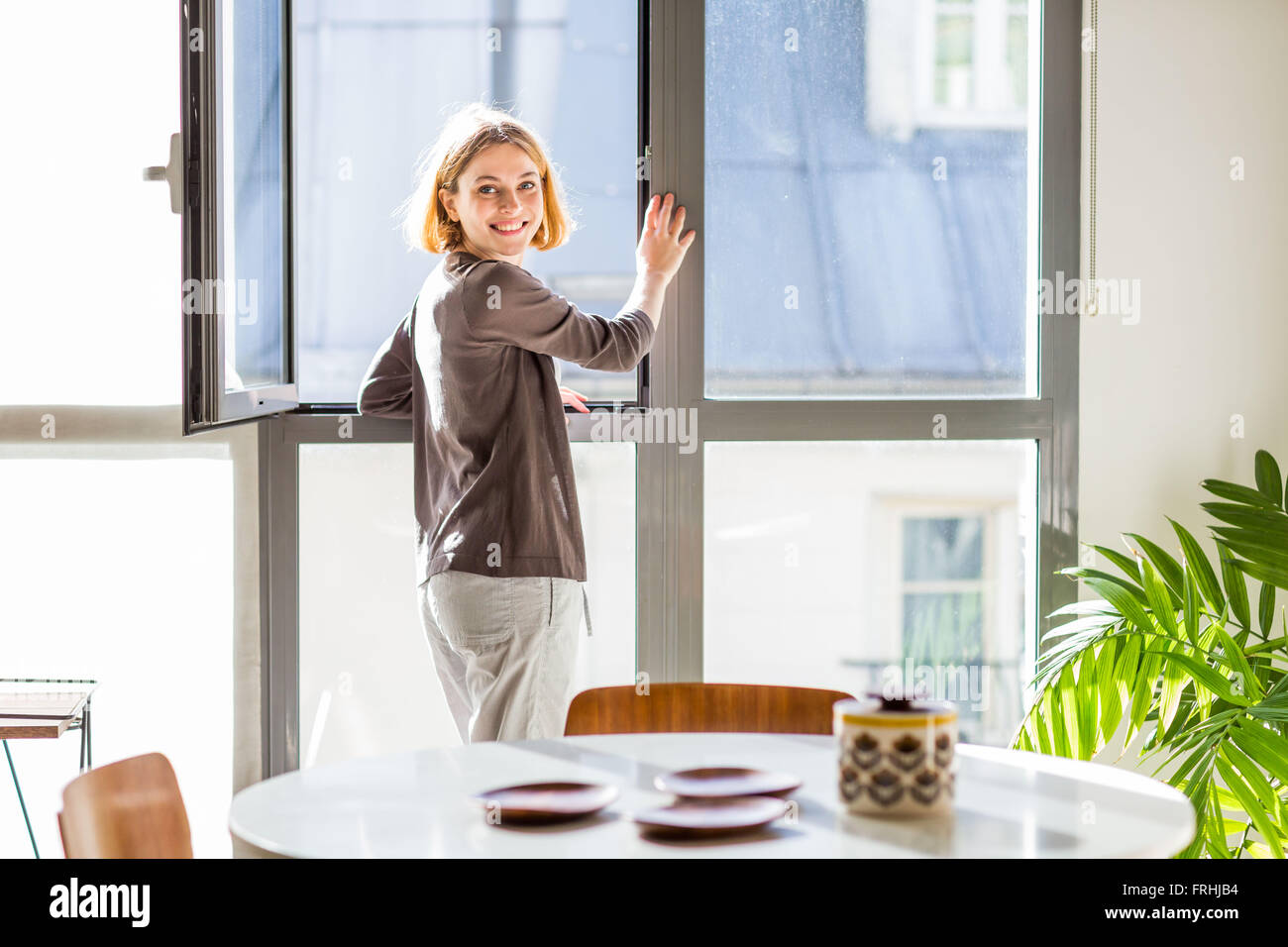Woman opening window Stock Photo - Alamy