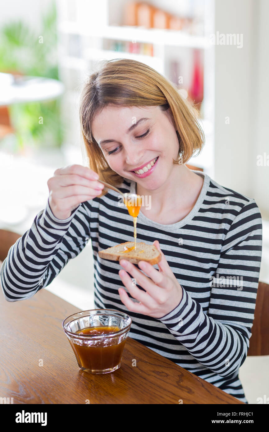 Woman eating honey Stock Photo - Alamy