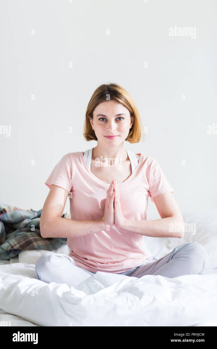Woman sitting on her bed Stock Photo - Alamy