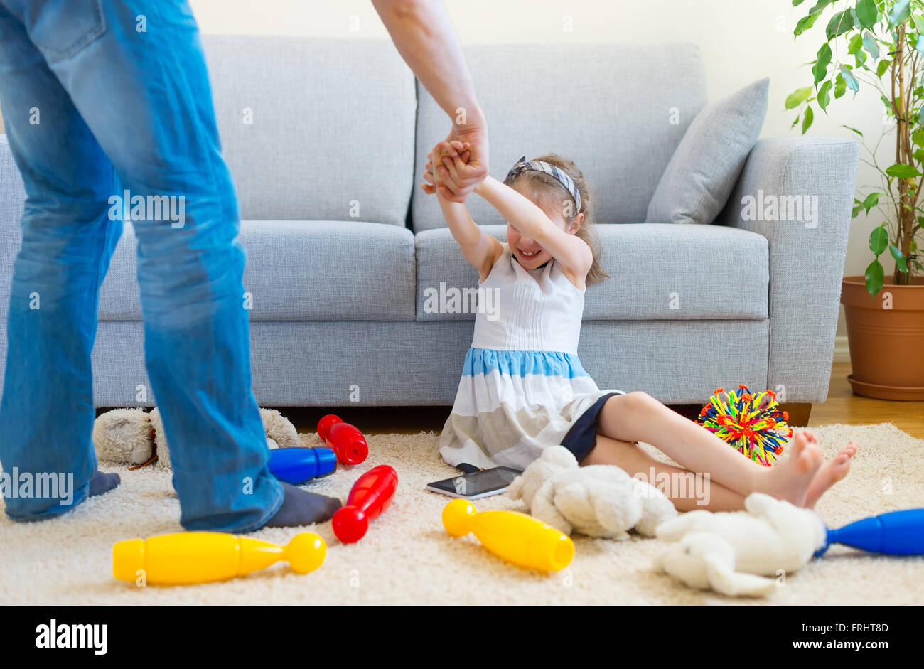 It's time to clean up your toys! Little girl playing with tablet pc ...