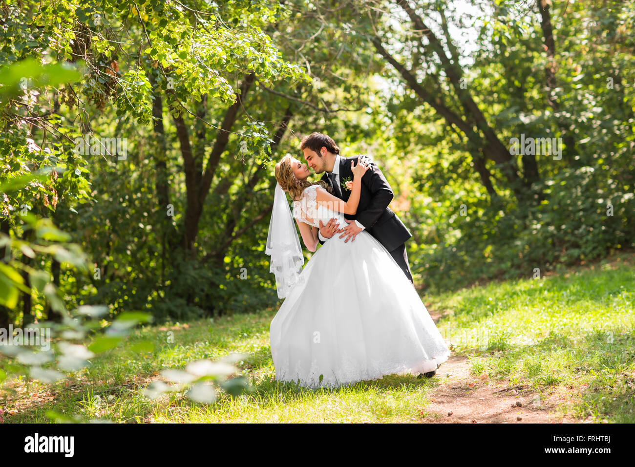 Beautiful wedding couple in park. They kiss and hug each other Stock ...