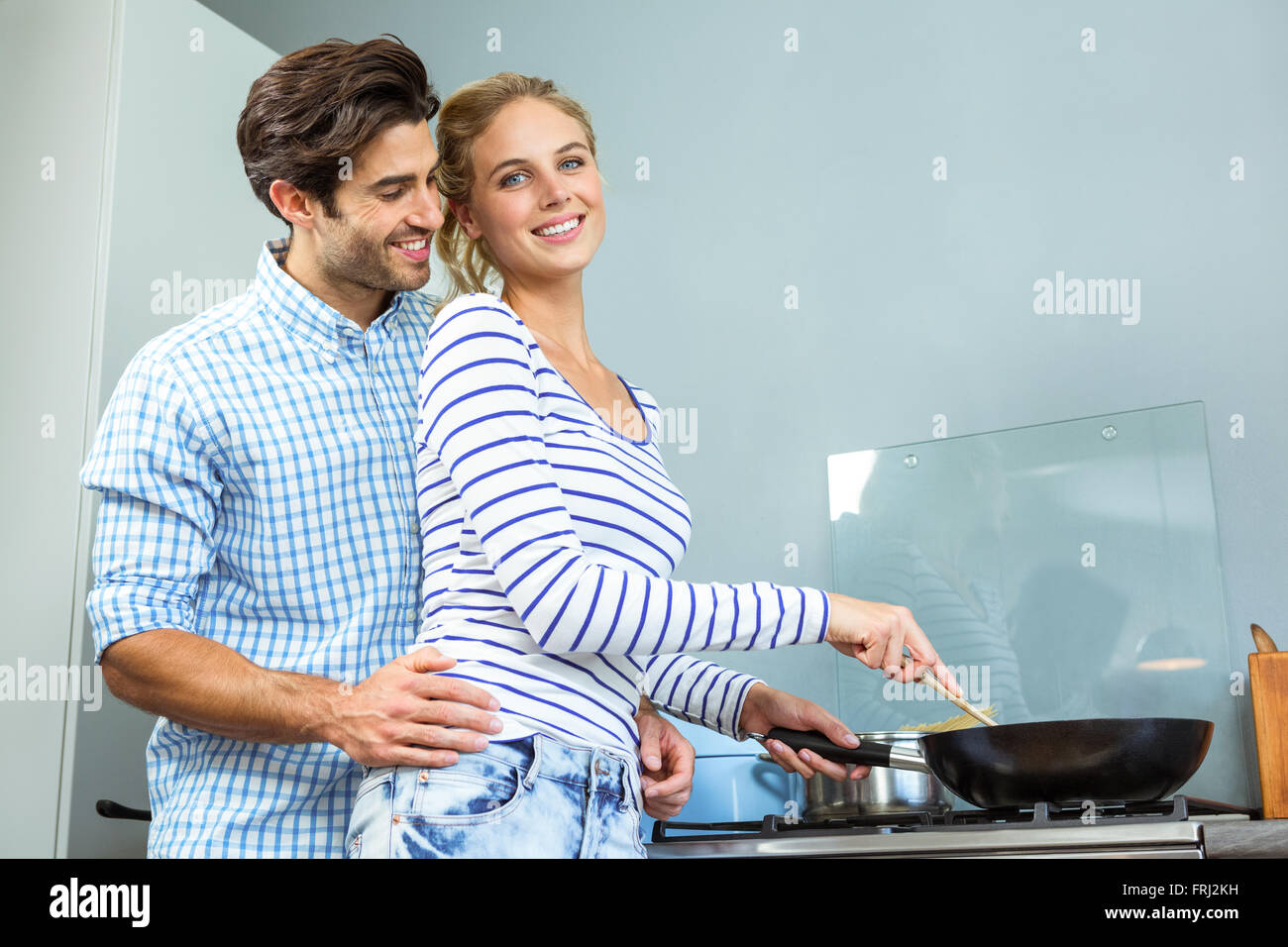 Young couple preparing food together in kitchen Stock Photo - Alamy