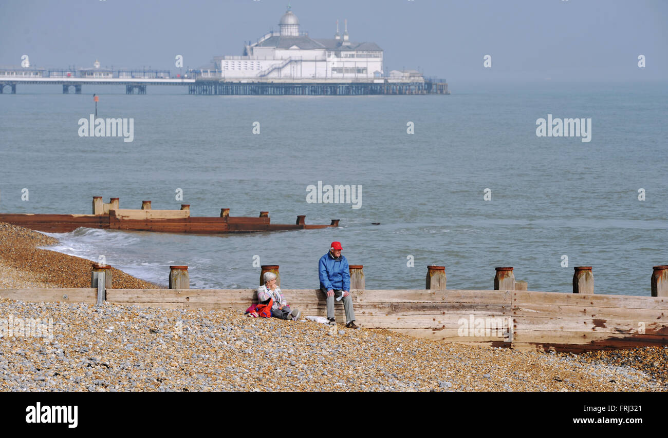 A couple sitting on the beach in beautiful spring sunshine weather in ...