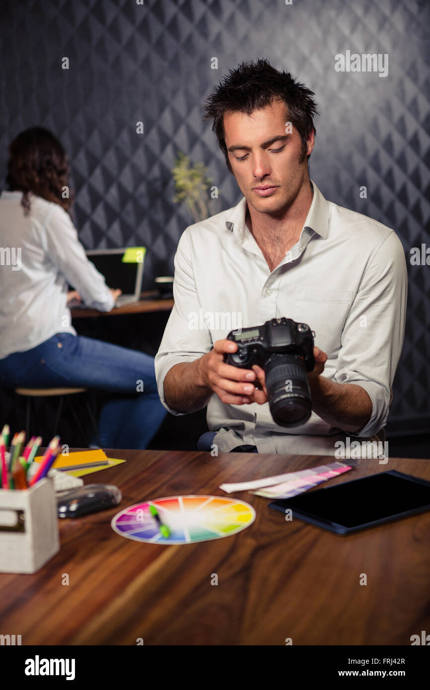 Creative businessman looking at picture on camera Stock Photo - Alamy