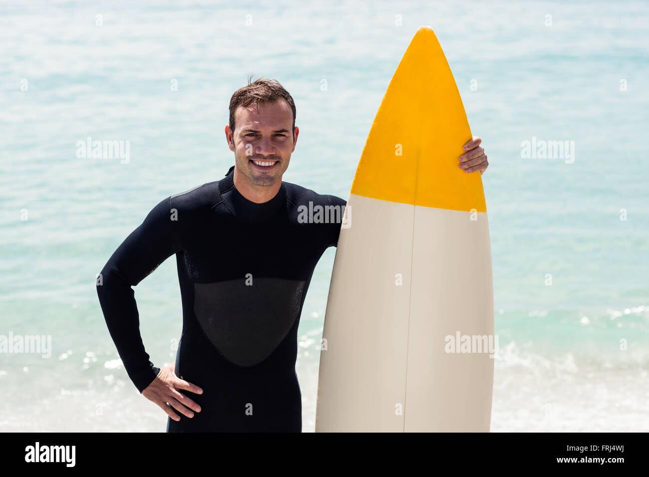 Happy surfer holding a surfboard on the beach Stock Photo - Alamy