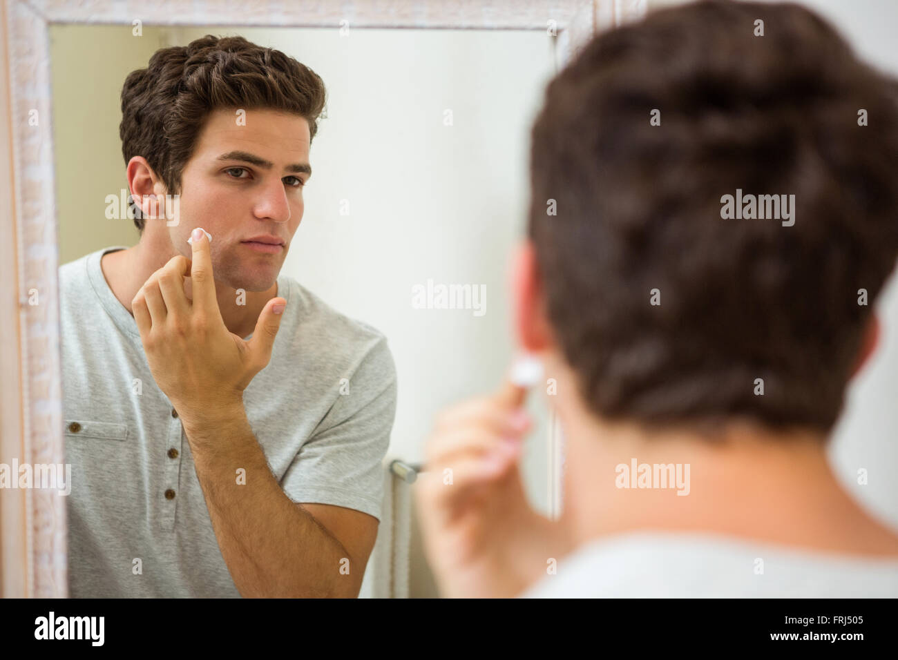 Man applying moisturizer on his face Stock Photo - Alamy