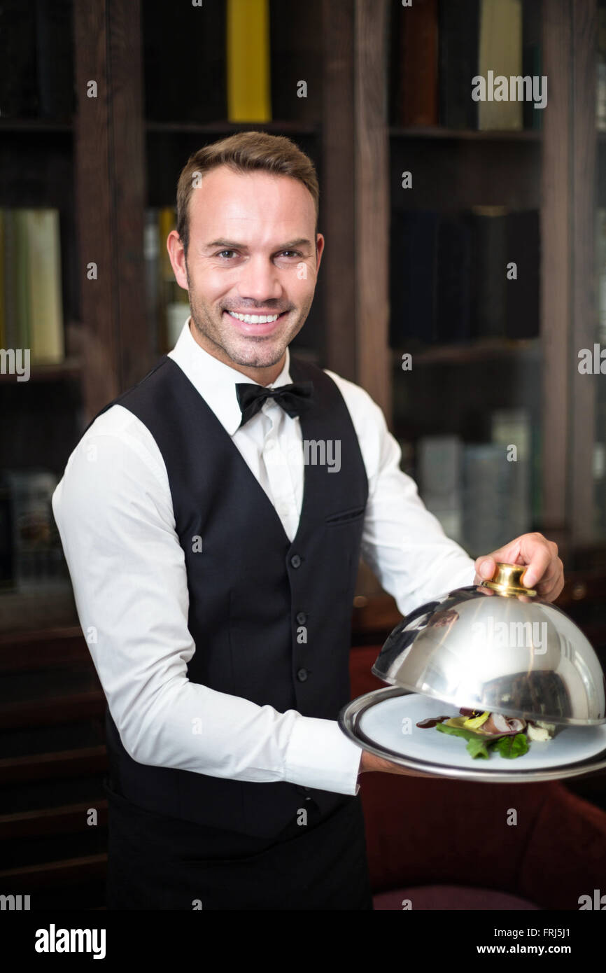 Handsome waiter serving meal Stock Photo - Alamy