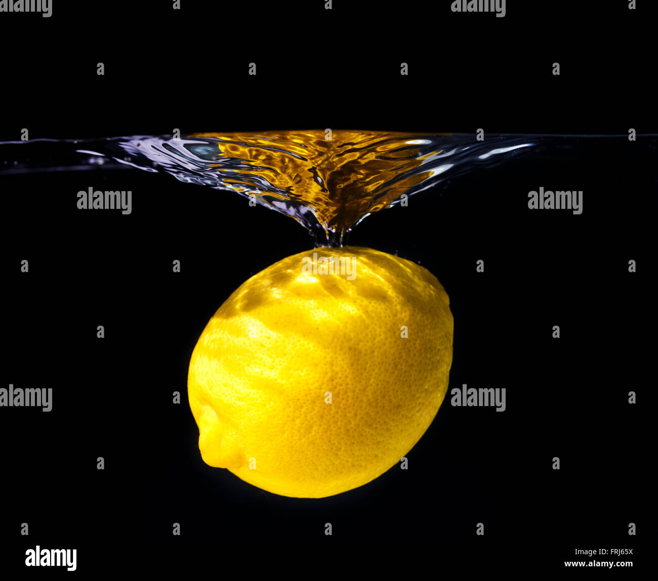 Yellow lemon in water splash on black Stock Photo - Alamy