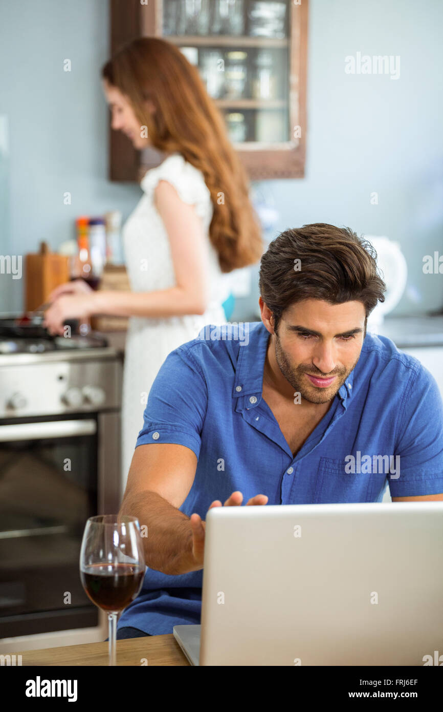 Man using laptop in kitchen Stock Photo - Alamy