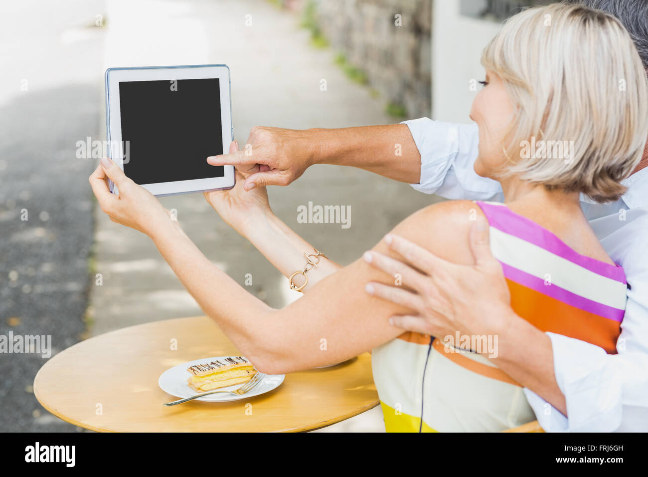 Rear view of man pointing at tablet Stock Photo - Alamy