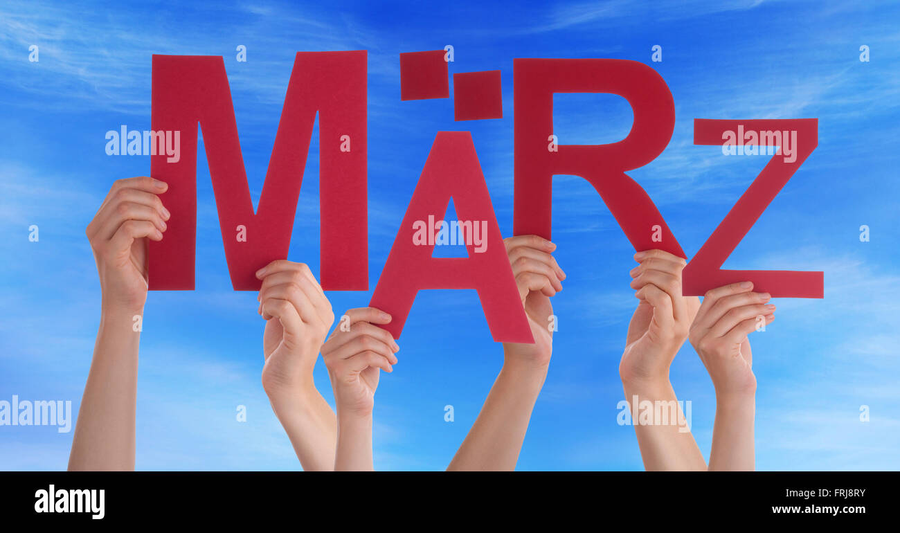 People Holding German Word Maerz Means March Blue Sky Stock Photo - Alamy