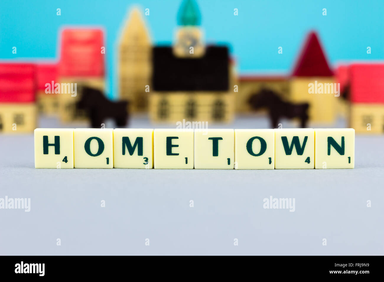Figurine hometown on blue background with sign Stock Photo - Alamy