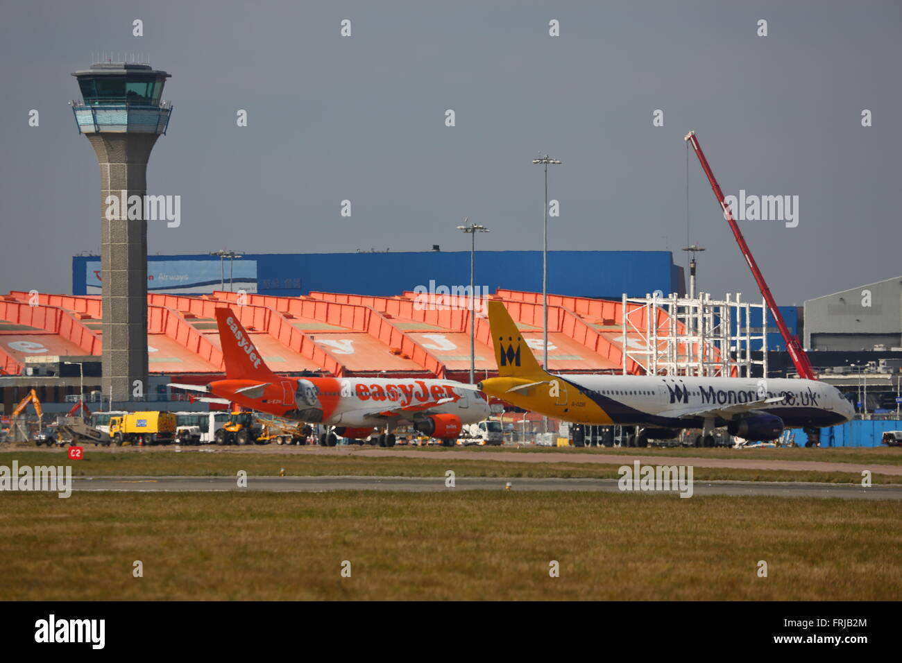 Luton Airport with air traffic control tower and planes at the gates ...