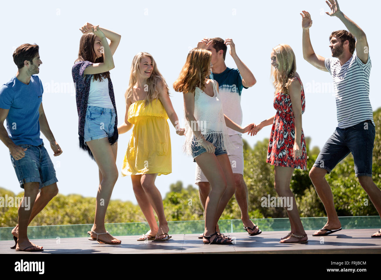 Happy friends dancing near the swimming pool Stock Photo - Alamy