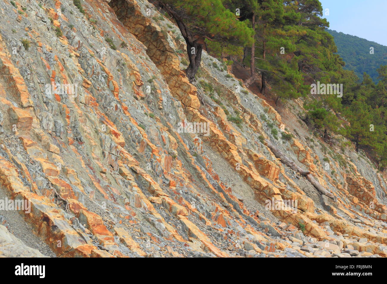 View on a steep slope with ledges of vertical folds of rocks Stock ...